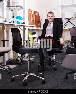 Young woman testing new chairs in salon Stock Photo - Alamy