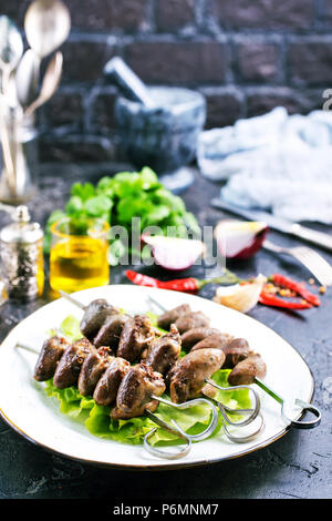 Fried hearts with spice. Chicken hearts kebab with salad on a plate top ...