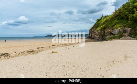 People walking on the beach at Benllech on the Isle of Anglesey. A blur ...