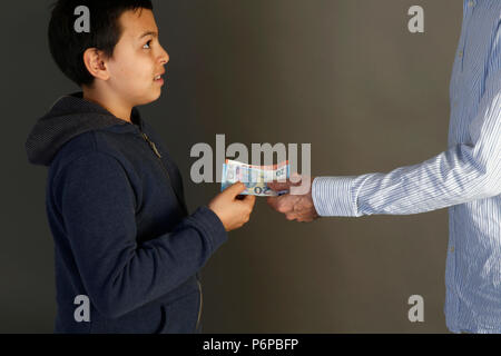 12-year-old boy receiving money from an adult. Paris, France Stock ...