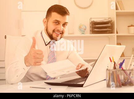Smiling man worker working effectively on project in office Stock Photo ...