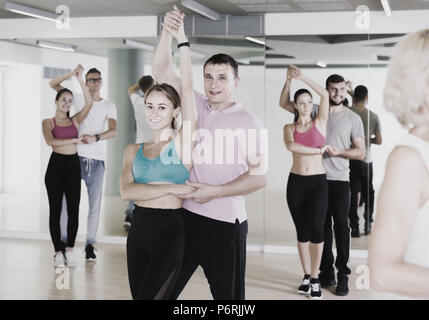Dancing positive couples learning salsa Stock Photo - Alamy