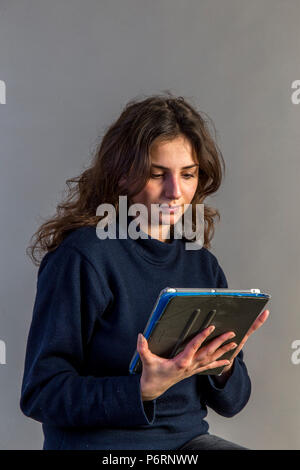 Young woman using digital tablet at desk Stock Photo - Alamy