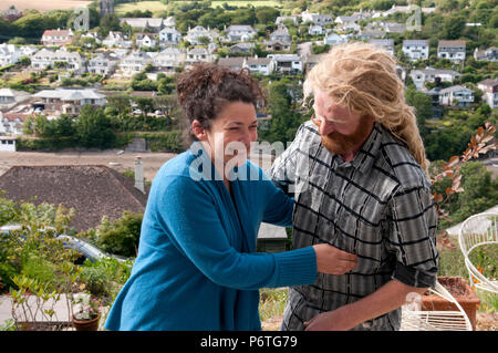 Loving happy woman with long curly hair playing with little son at home ...