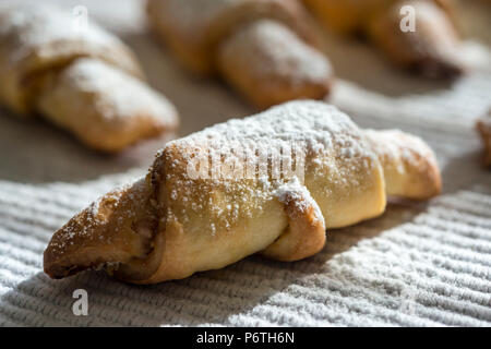 Closeup shot of a croissant and a cinnamon roll on a dark grey table ...