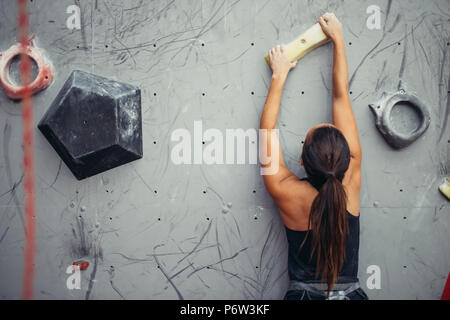 Close-up of artificial handles, hooks and bolders. Hands of climber on ...