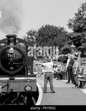 Railway signalman on SVR heritage line looks out window to greet train ...