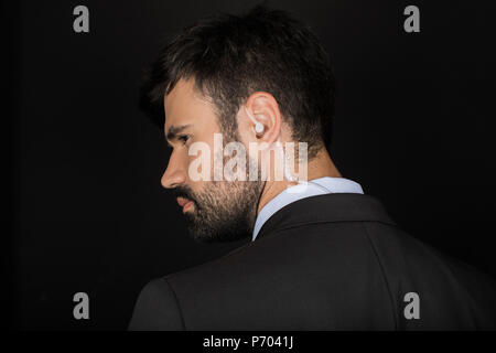 Secret service agent in suit using earphone, isolated on black Stock ...
