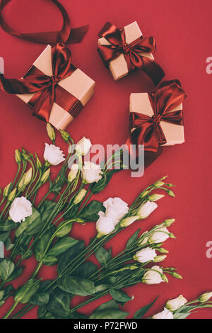Beautiful gifts with red ribbons and flowers, close up Stock Photo - Alamy