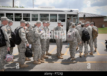 U.S. Army flight school students at Fort Rucker, Ala. load up a bus ...