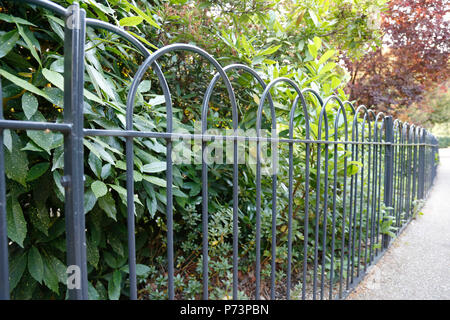 Park wrought iron railings with green foliage in the background Stock ...