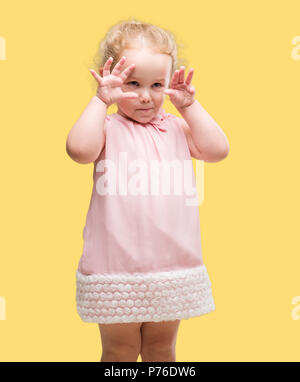 Beautiful blonde toddler gesturing Stock Photo - Alamy