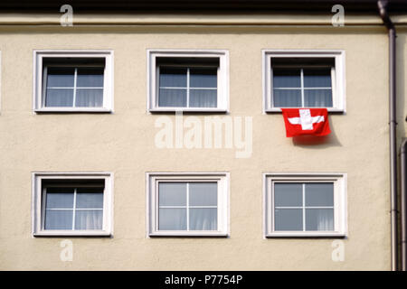A Swiss national flag hangs from the window of a residential building ...