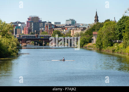 A man sculling in a single scull rowing boat, on the water. Overhead ...