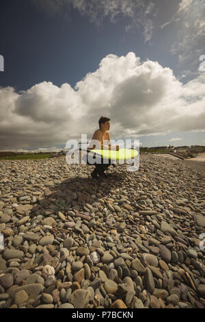 Young male surfer crouching on his surfboard in a tube Stock Photo - Alamy