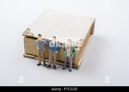Tiny figurine of men models found beside a book Stock Photo - Alamy