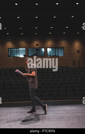 Female actress reading script on stage Stock Photo - Alamy