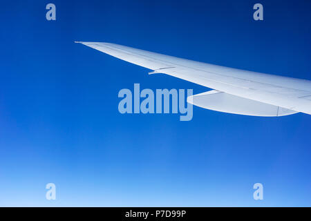 Travel concept. Wing of airplane flying above the clouds in trendy ...