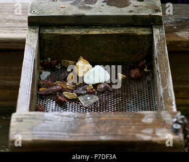 Gemstone panning with a sluice box. Sifting for stones and fossils at ...