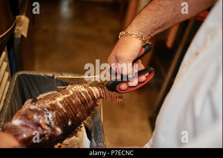 Fisherman cutting the poisonous spines off invasive lionfish that he ...