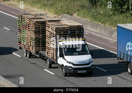 Iveco truck with flat bed trailer and boom lift being loaded Stock ...