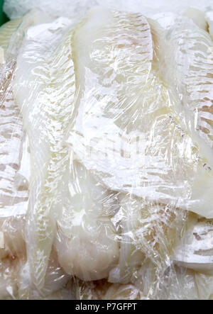 uncooked raw fillet of cod with serving spices on white background ...