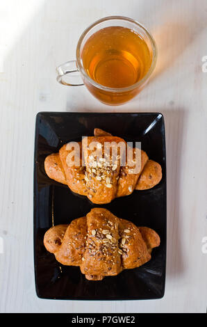cup of fragrant coffee and croissants with butter on a wooden table ...