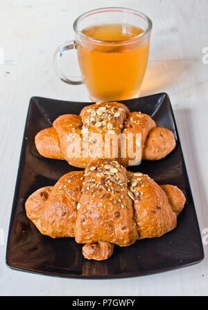 cup of fragrant coffee and croissants with butter on a wooden table ...