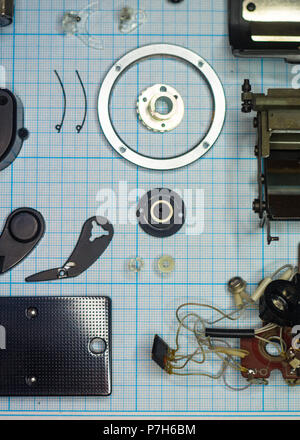 parts are completely disassembled old retro film SLR camera on graph ...
