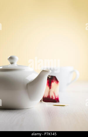 A cup of tea and teapot with tea bag on wooden table Stock Photo - Alamy