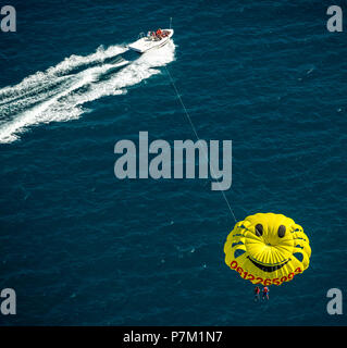 Aerial view, parasailing, parachute with a smiley face drawn by a motor ...
