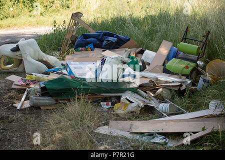 Rubbish dumped in the entrance to a field next to a rural road in ...