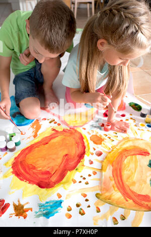 Kids painting together on a large piece of paper Stock Photo - Alamy