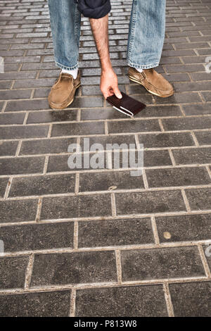 man finding a wallet lost on the ground and picking it up Stock Photo ...