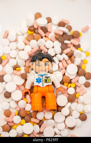 concept shot lego doctor doll surrounded by a pile of pills and drugs ...