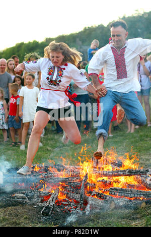 Ukrainian people jump over fire during a traditional Ukrainian ...
