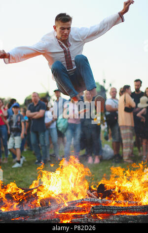 Ukrainian people jump over fire during a traditional Ukrainian ...