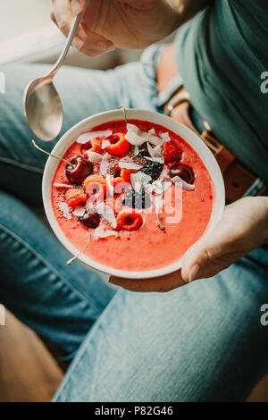 young woman eating chia pudding with nuts and berries Stock Photo - Alamy