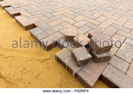 Block paving being laid on a driveway - close up shot of the edging ...
