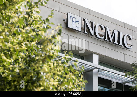 A logo sign outside of the headquarters of the NCMIC Group, Inc., in ...