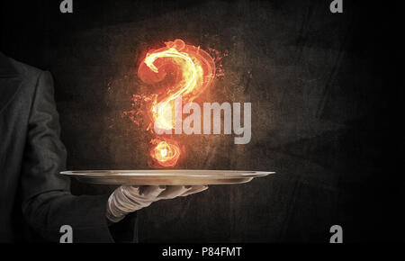 Hand of waitress presenting flaming question mark Stock Photo - Alamy