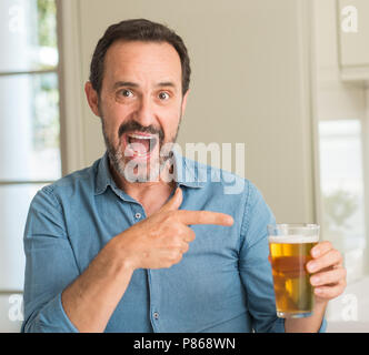 Handsome senior man drinking beer at restaurant very happy and excited ...