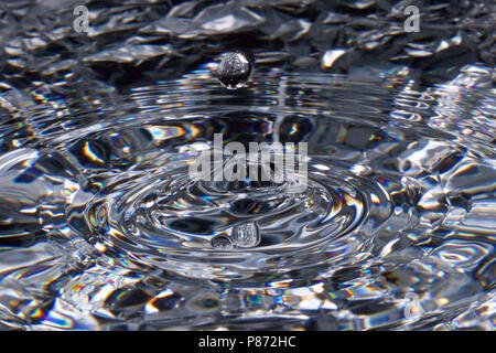 Water droplets falling into water causing splashes and ripples Stock ...