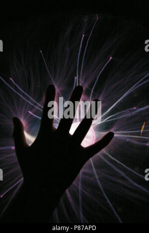 Hand on plasma lamp looks like bolt of electricity charging from hand ...
