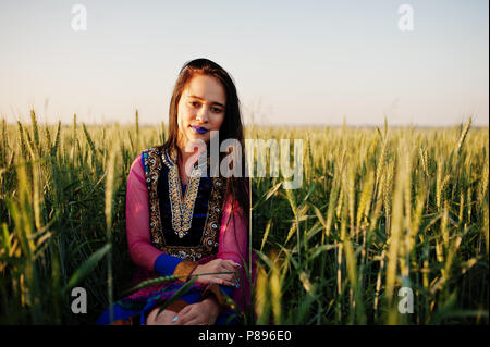 Tender indian girl in saree, with violet lips make up posed at field in ...