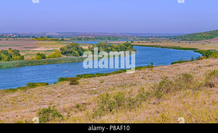 Wide river flowing between fields Stock Photo - Alamy