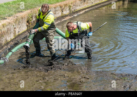 Workers using a suction pump to remove mud and silt in a lake Stock ...