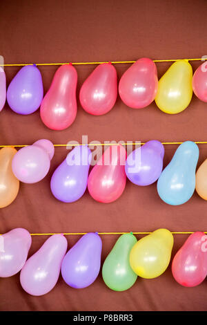 Balloon shooting game with balloons tied on a string Stock Photo - Alamy