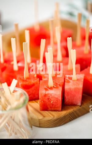 Preparing watermelon appetizers dipped in chocolate and sprinked with ...