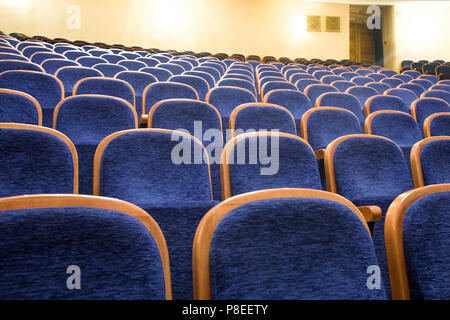 Cinema movie theatre with blue seats and a blank white screen ...